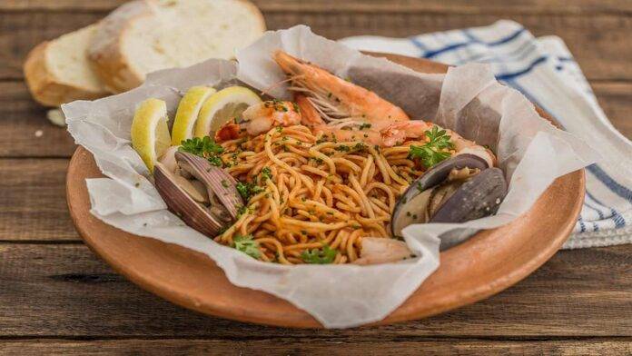 Spaghetti alla pescatora al cartoccio | Un primo piatto ricco di gusto